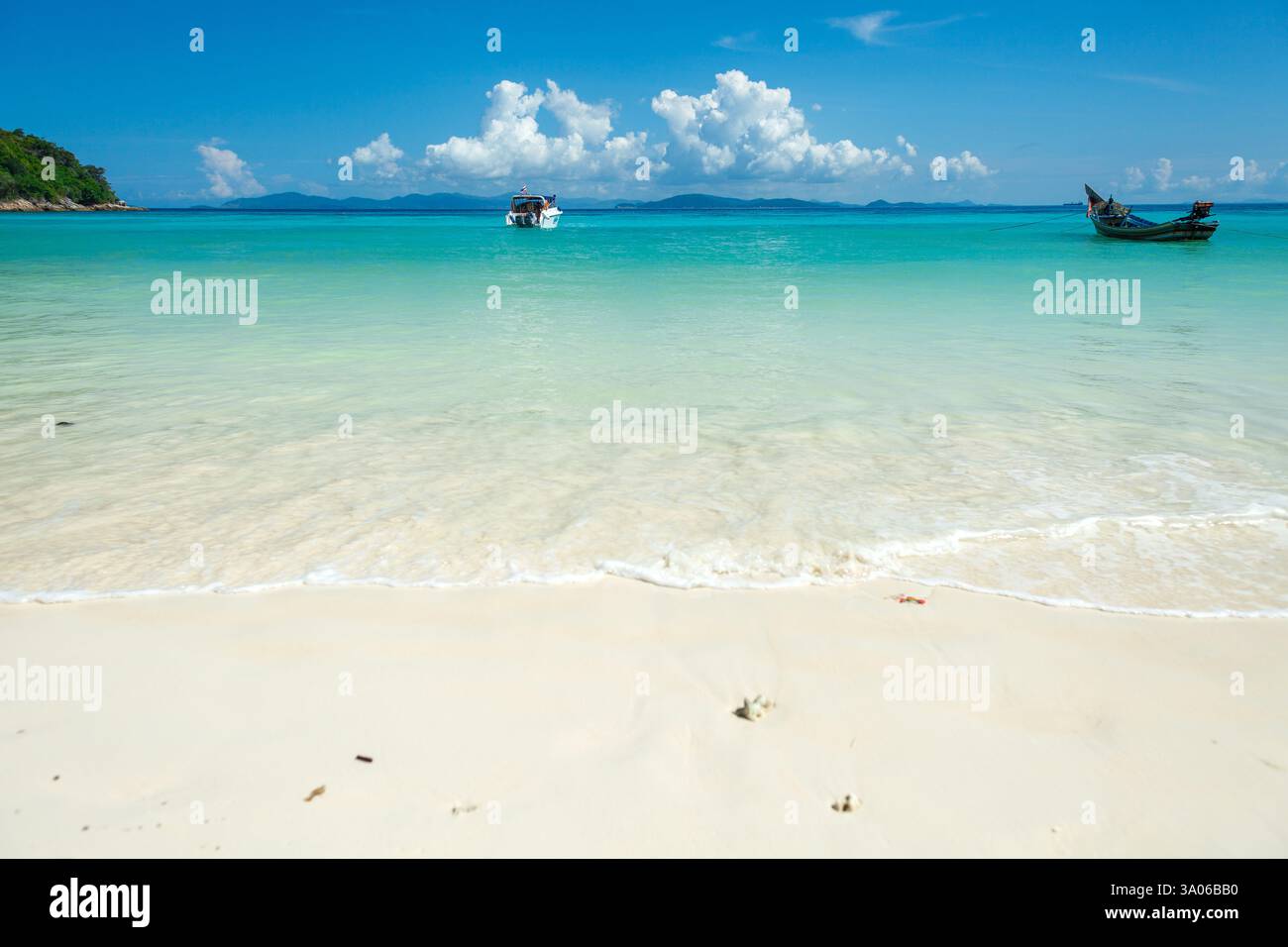 traditional thai wooden boat an a modern motor launch in a bay of the ...