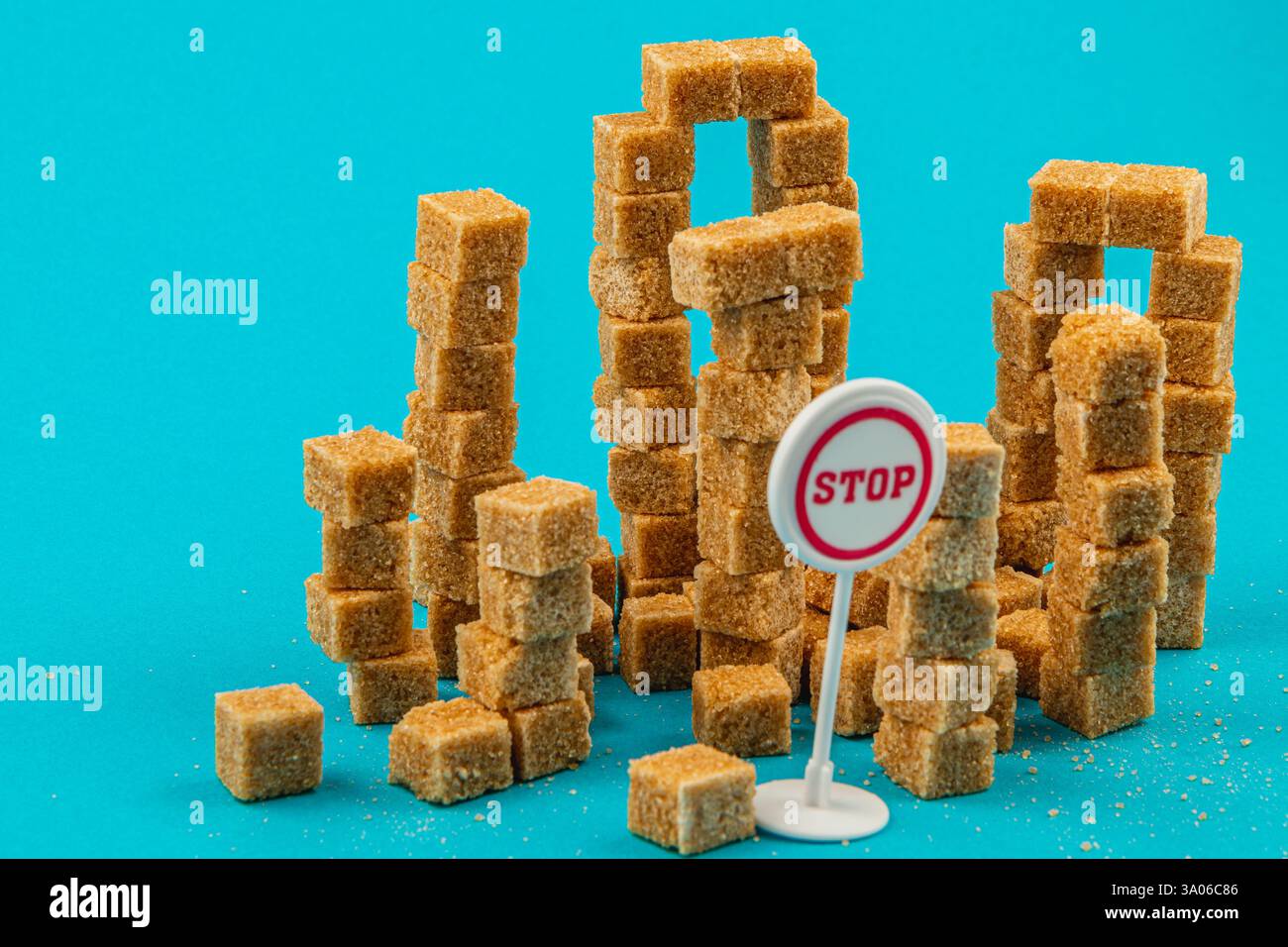 Stacked sugar cubes create a cityscape while a stop sign stands amidst ...