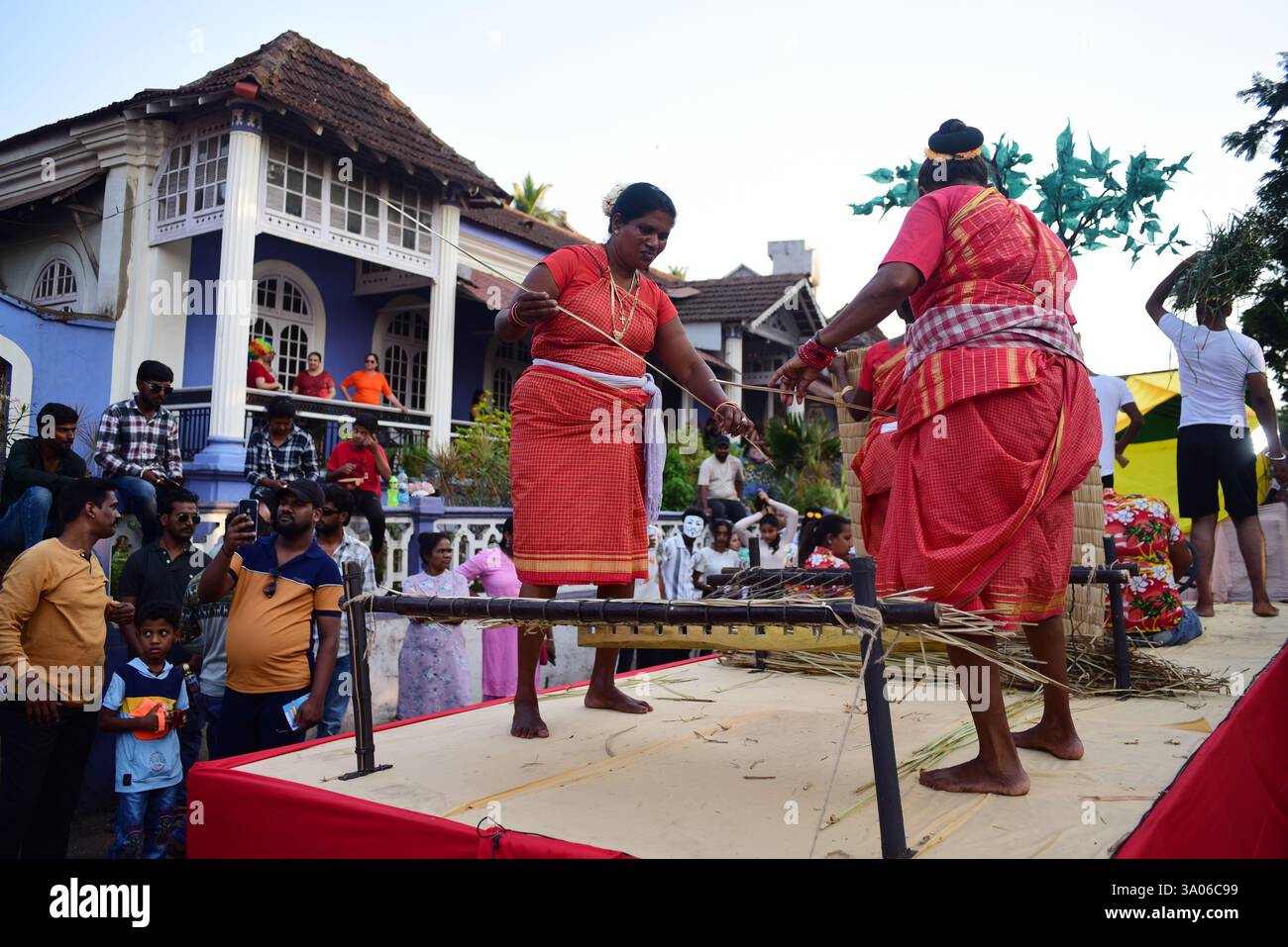 Women dressed in traditional attire seen weaving traditional bed and ...
