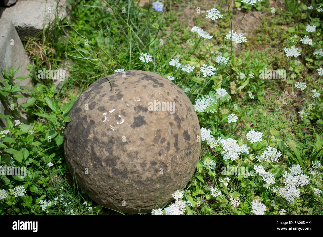 Round stone ball over green grassy background Stock Photo - Alamy