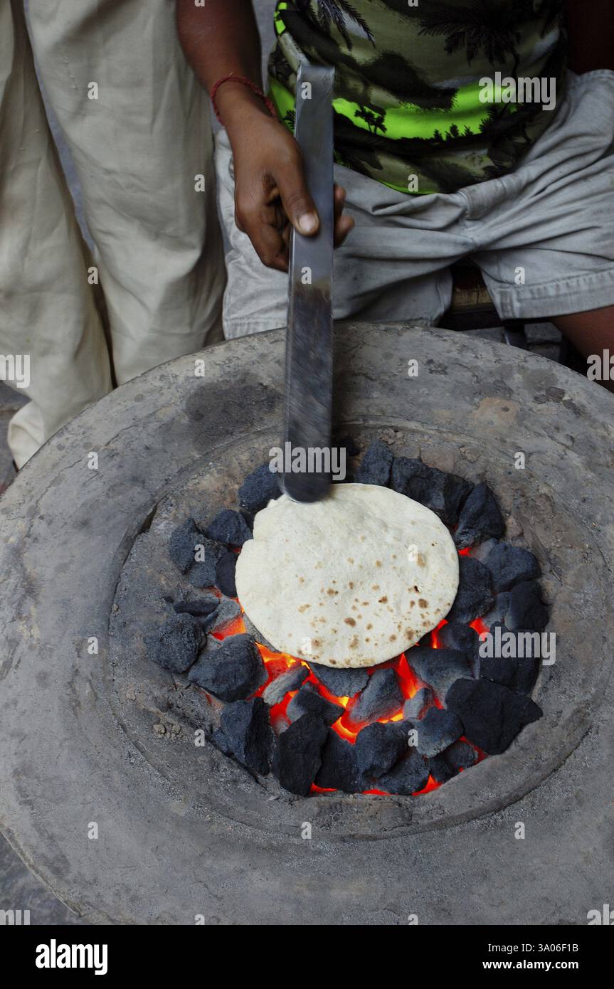 Indian Bread, Roti being made on hot coals in outdoor tandoor, New ...