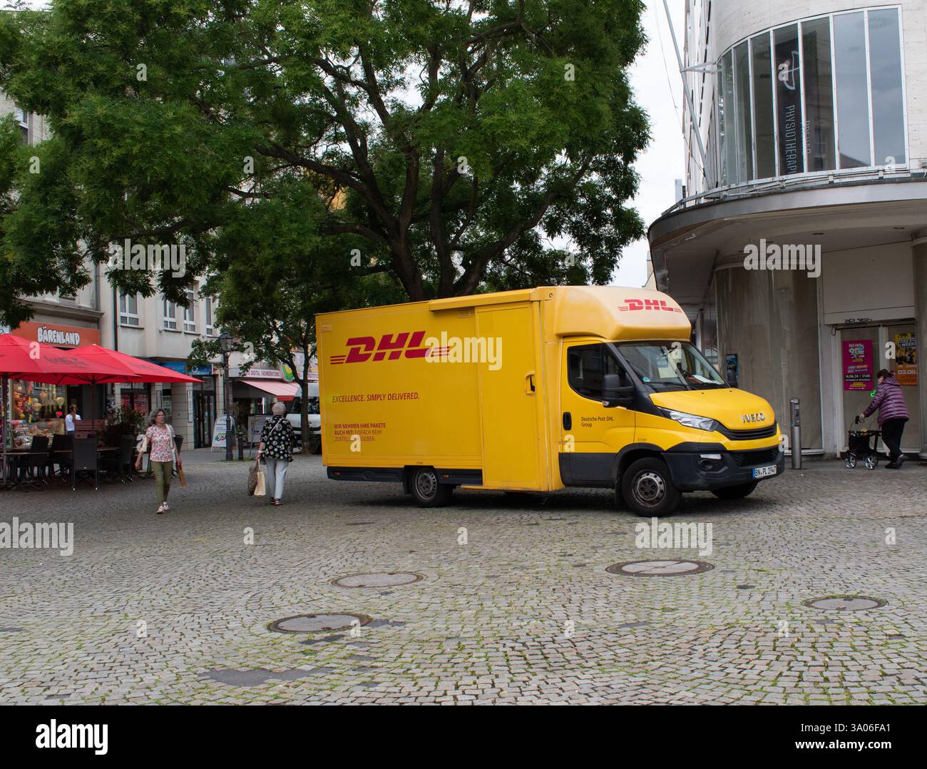 Yellow DHL delivery van, courier driving through city centre Stock ...