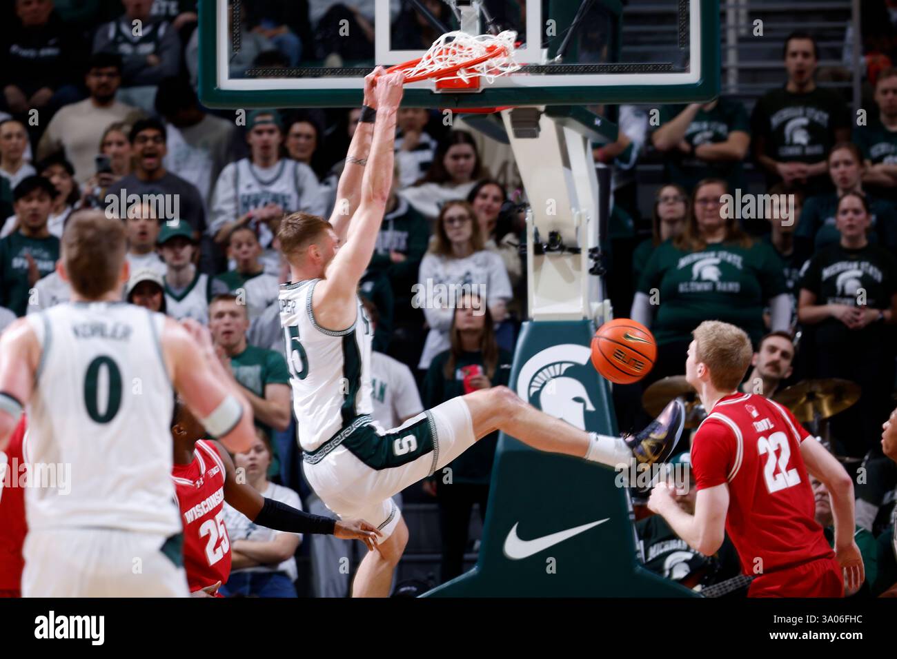 Michigan State center Carson Cooper dunks against Wisconsin forward ...