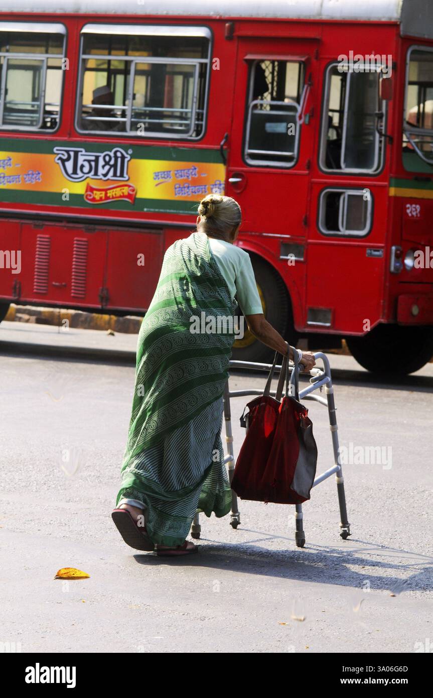 Lady using walker for walking on street limping Stock Photo - Alamy