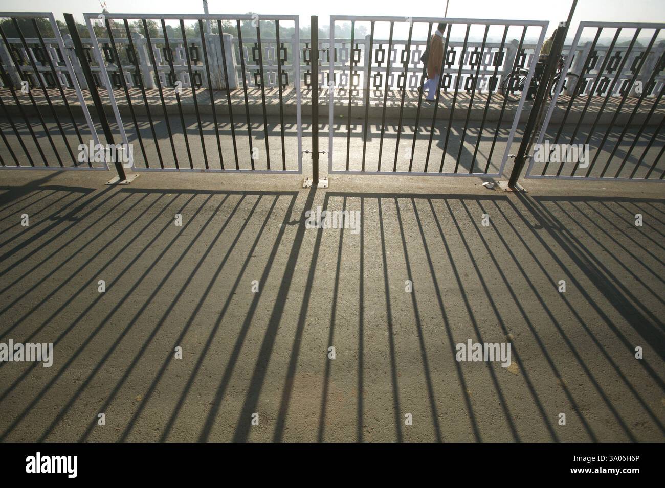 Shadows of grill divider on road, bridge over river Godavari in Nanded ...