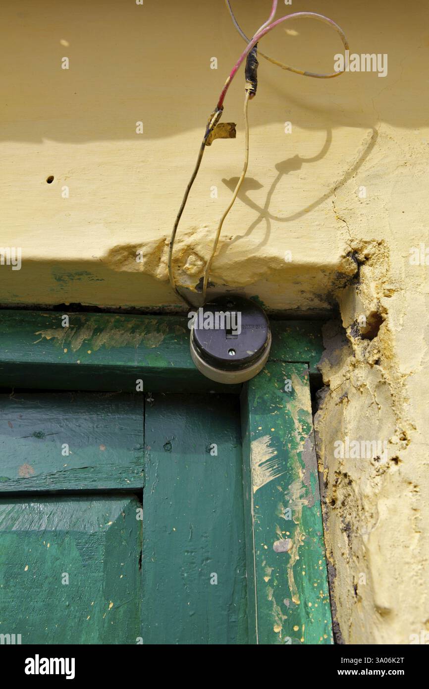 Wire dangling from old switch on green door of house, Rajpur, Dehradun ...