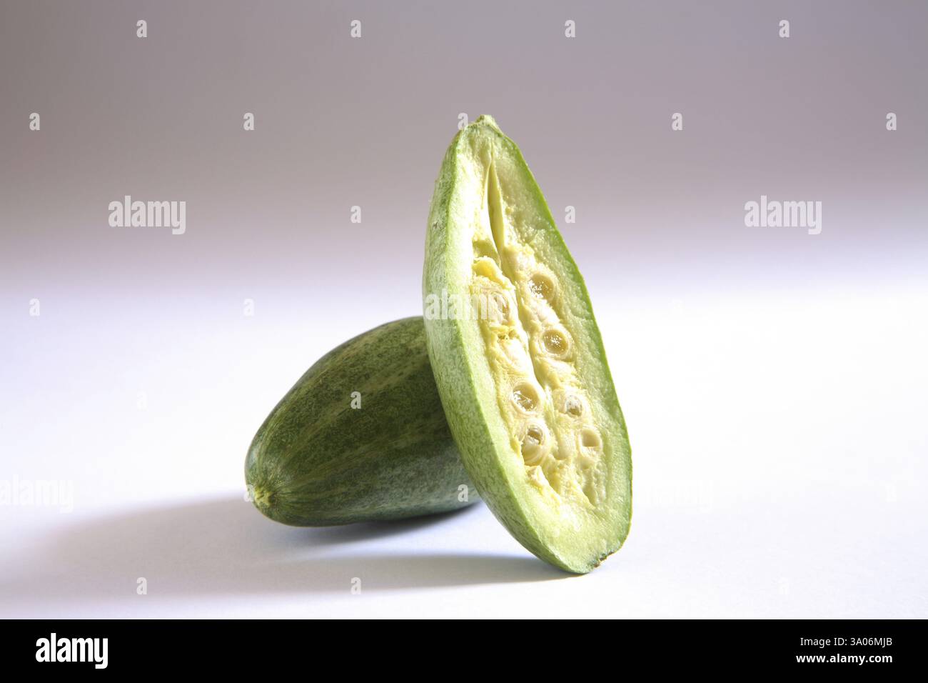 Vegetable, one full and half striped pear gourds parwal on white ...