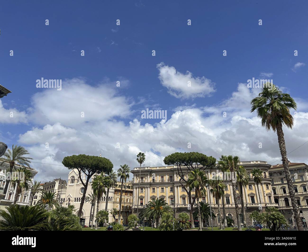 Palm tree lined avenue with classical architecture under a blue sky ...