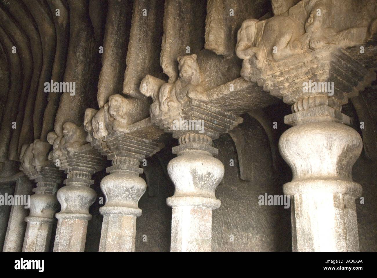 Richly carved pillars in Buddhist caves on mountain at Lenyadri, taluka ...