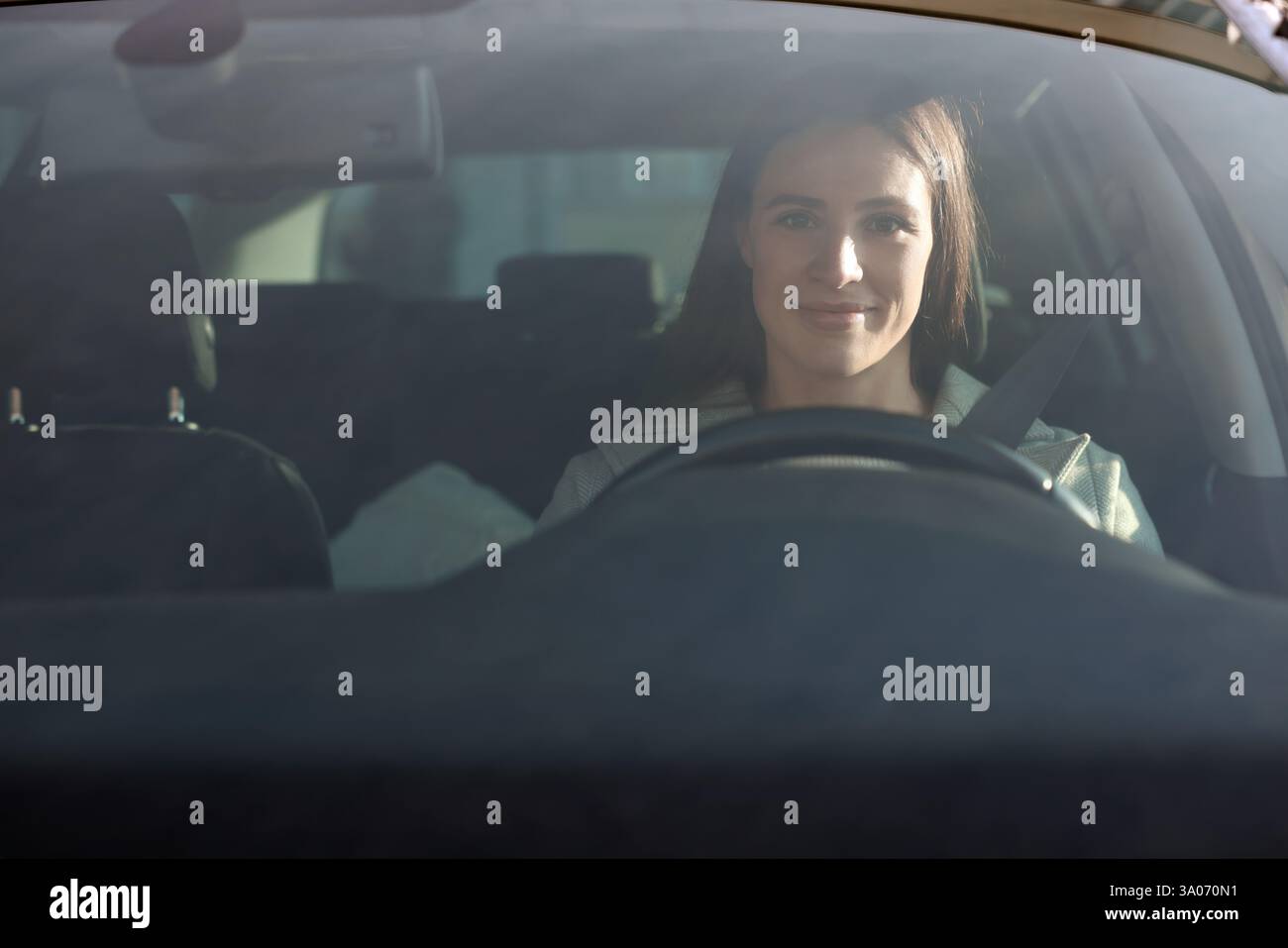 Driver behind steering wheel of modern car, view from windshield Stock ...