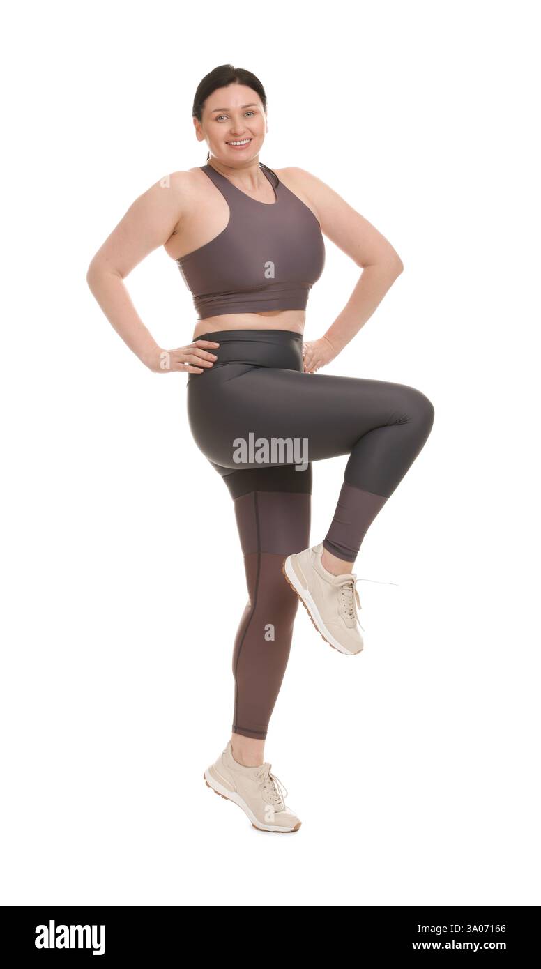 Plus size woman in gym clothes exercising on white background Stock ...