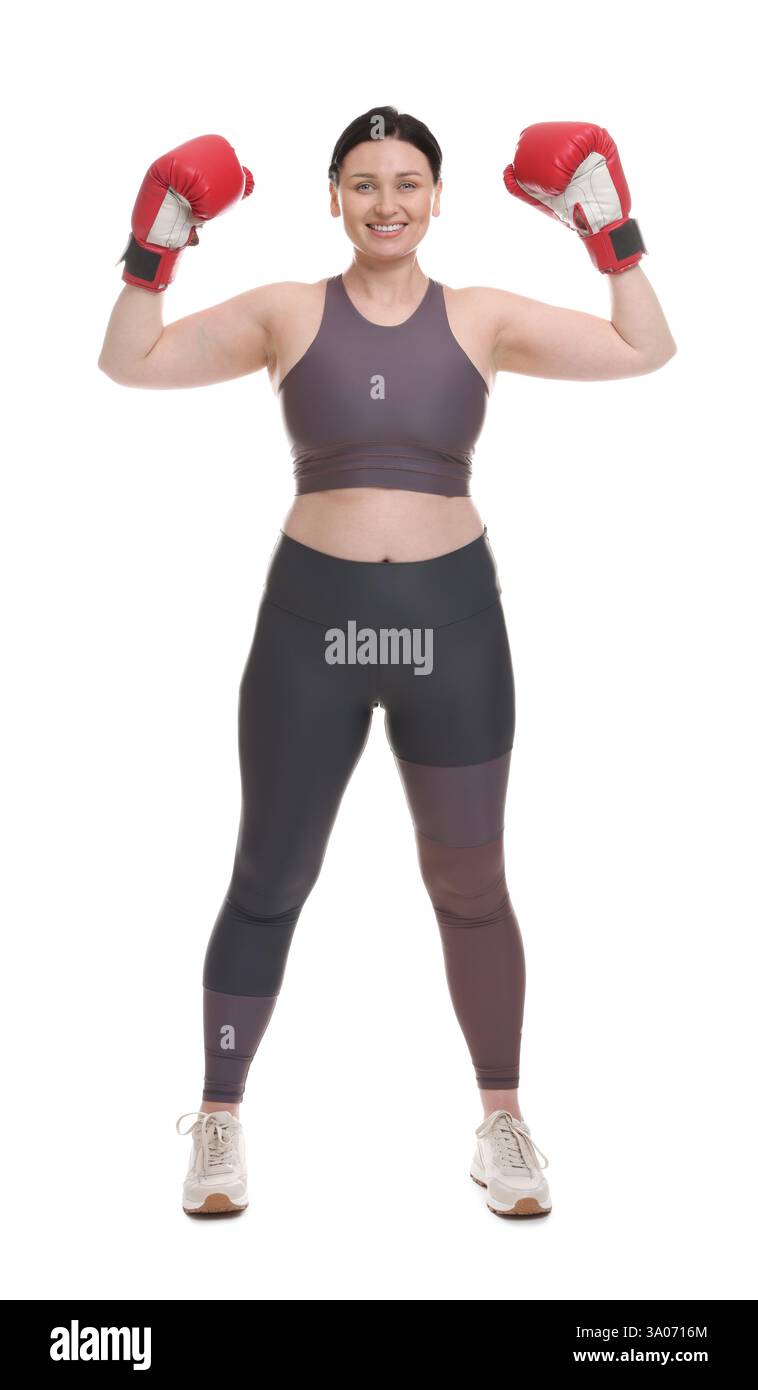 Plus size woman in gym clothes and boxing gloves on white background ...