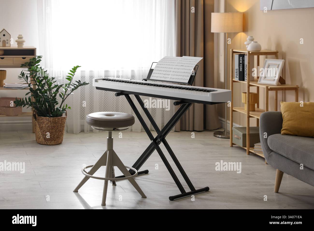 Synthesizer with music sheets and stool indoors Stock Photo - Alamy