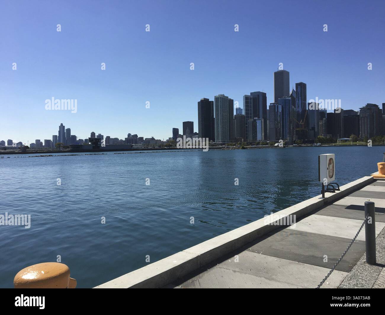 Skyline of a waterfront city with modern skyscrapers under a clear blue ...