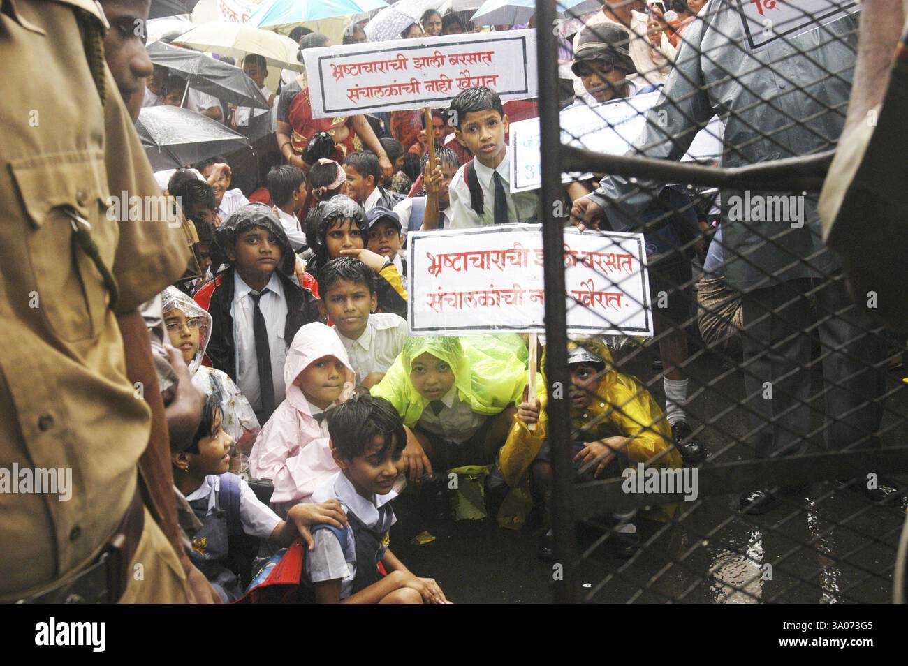 School children with parents protesting during rain against corruption ...