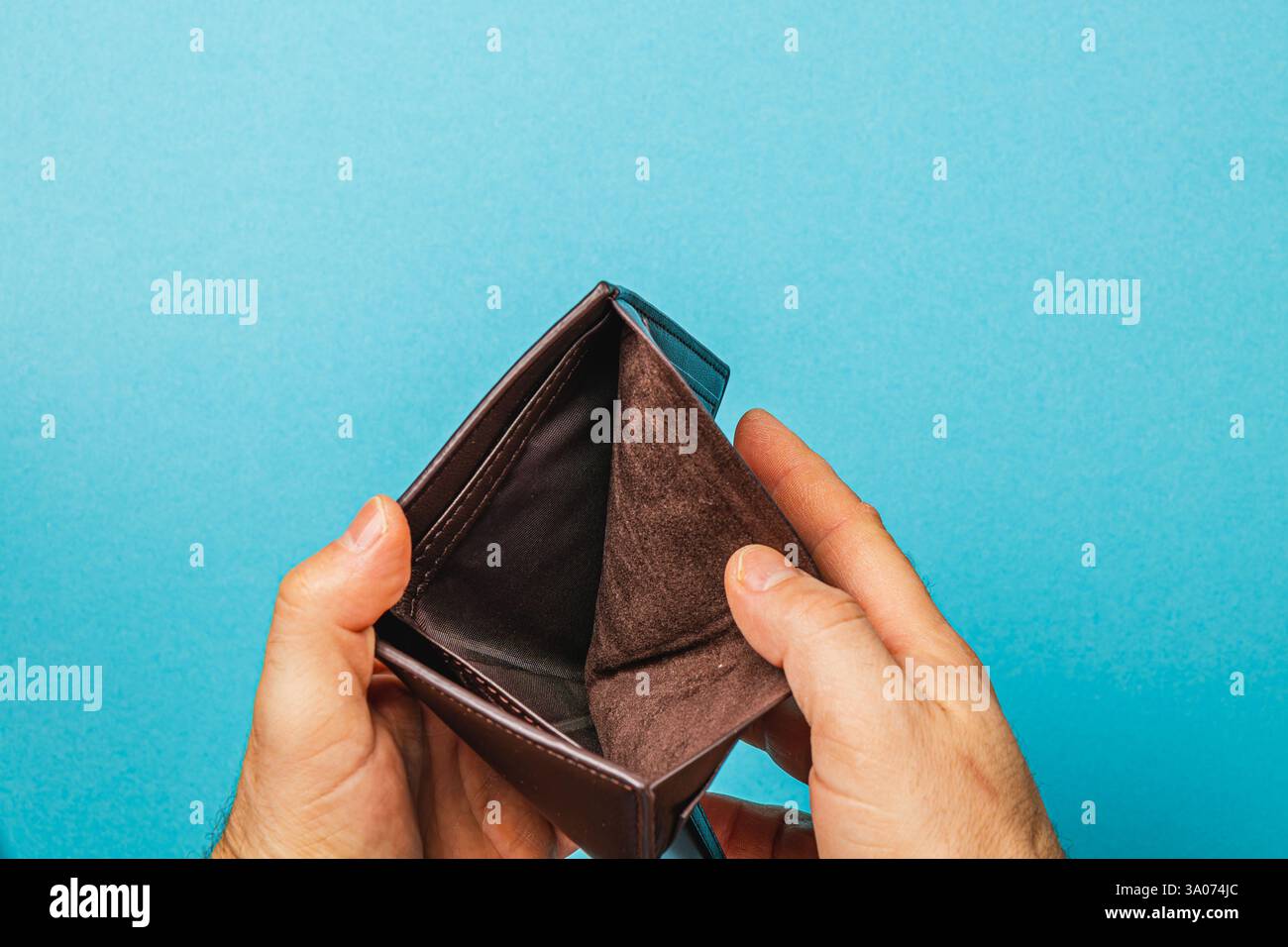 A man holds an empty wallet, reflecting despair and financial struggle ...