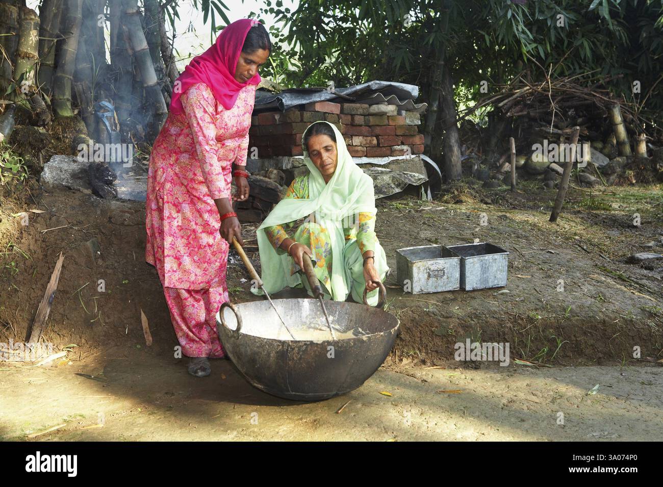 Rural women mixing boiling ingredients making washing soap economic ...