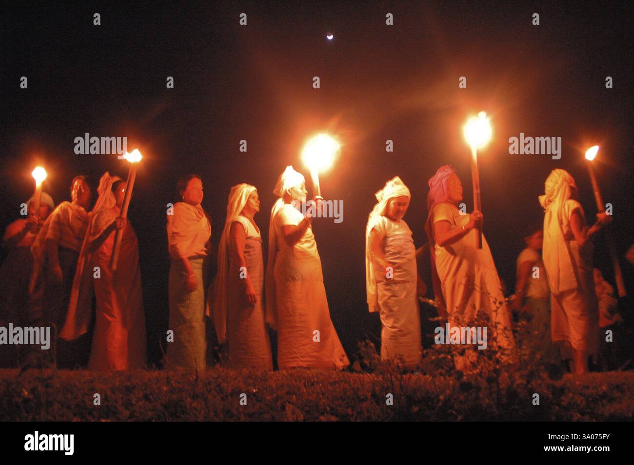 Meira paibis (torch bearers) present themselves with burning torches to ...