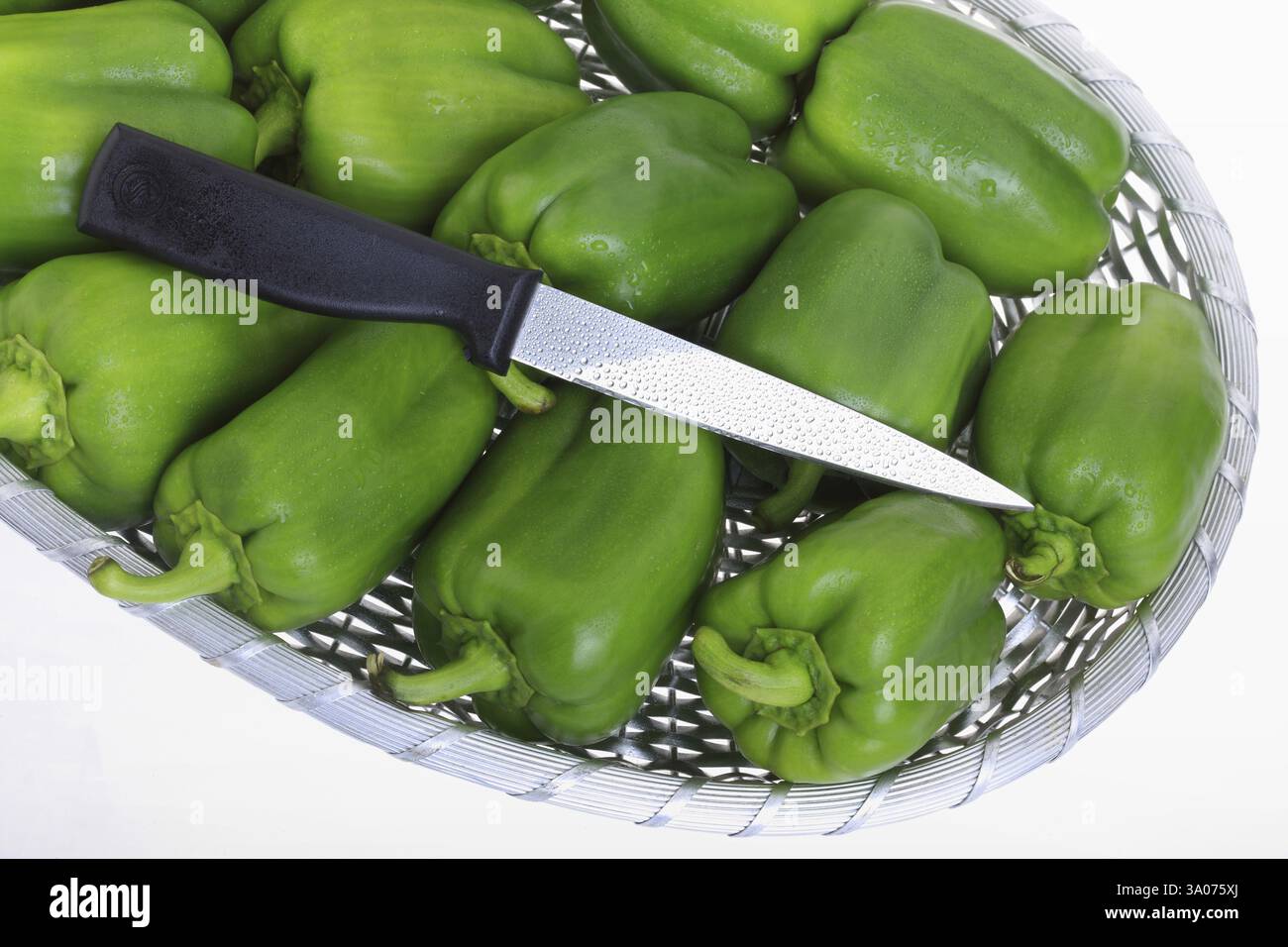 Green Capsicums Latin Capsicum Annuum in a basket with two Sharp knife ...