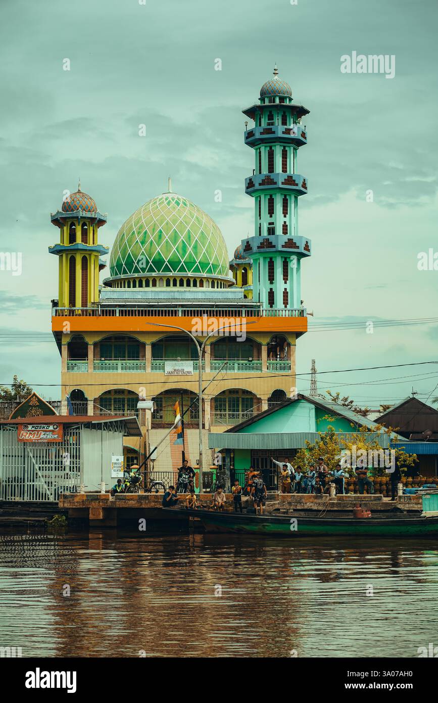 A mosque located by the riverside, surrounded by traditional wooden ...