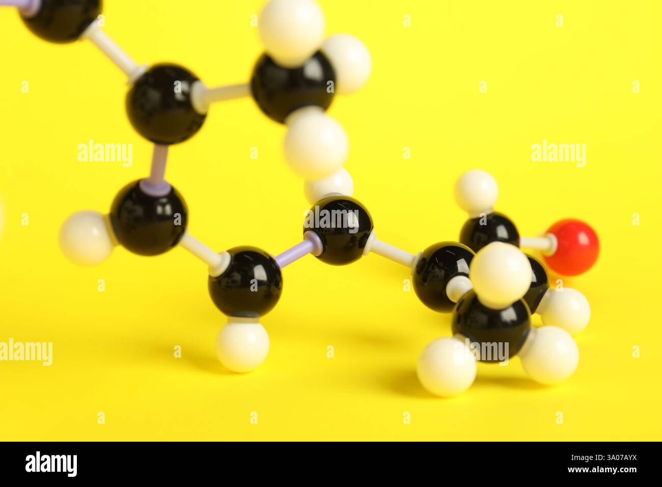 Molecule of retinol (vitamin A) on yellow background, closeup. Chemical ...