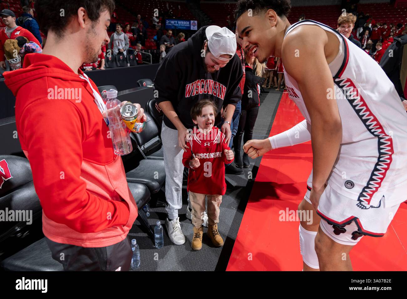 Wisconsin Badgers guard John Tonje (9) signs a jersey of a young fan ...