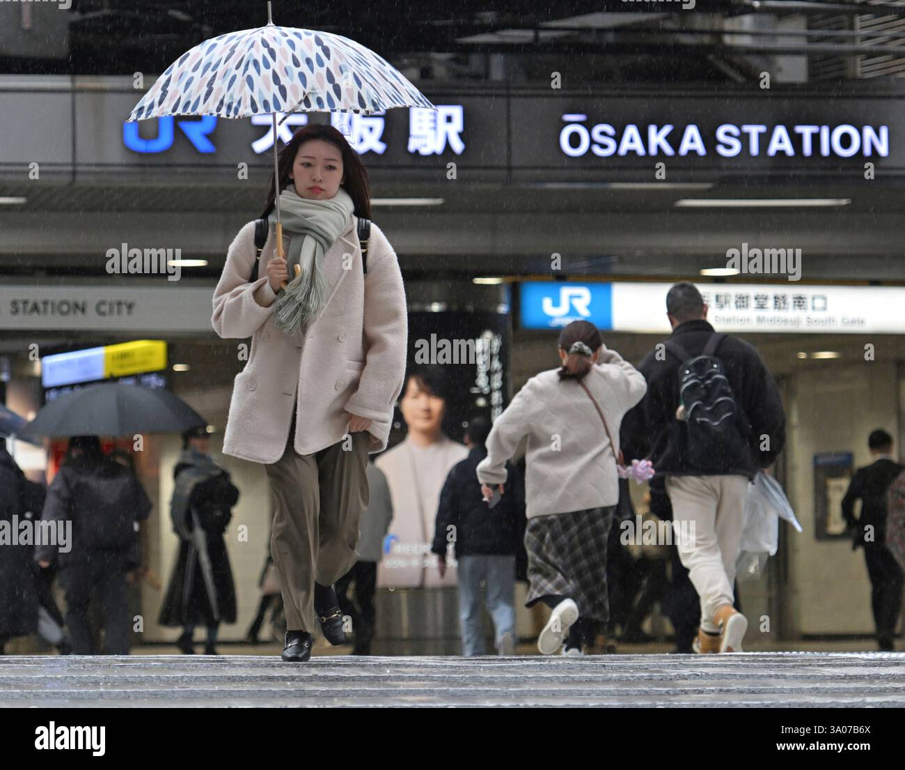 Commuters and others walk in the cold rain in near Osaka Station in ...