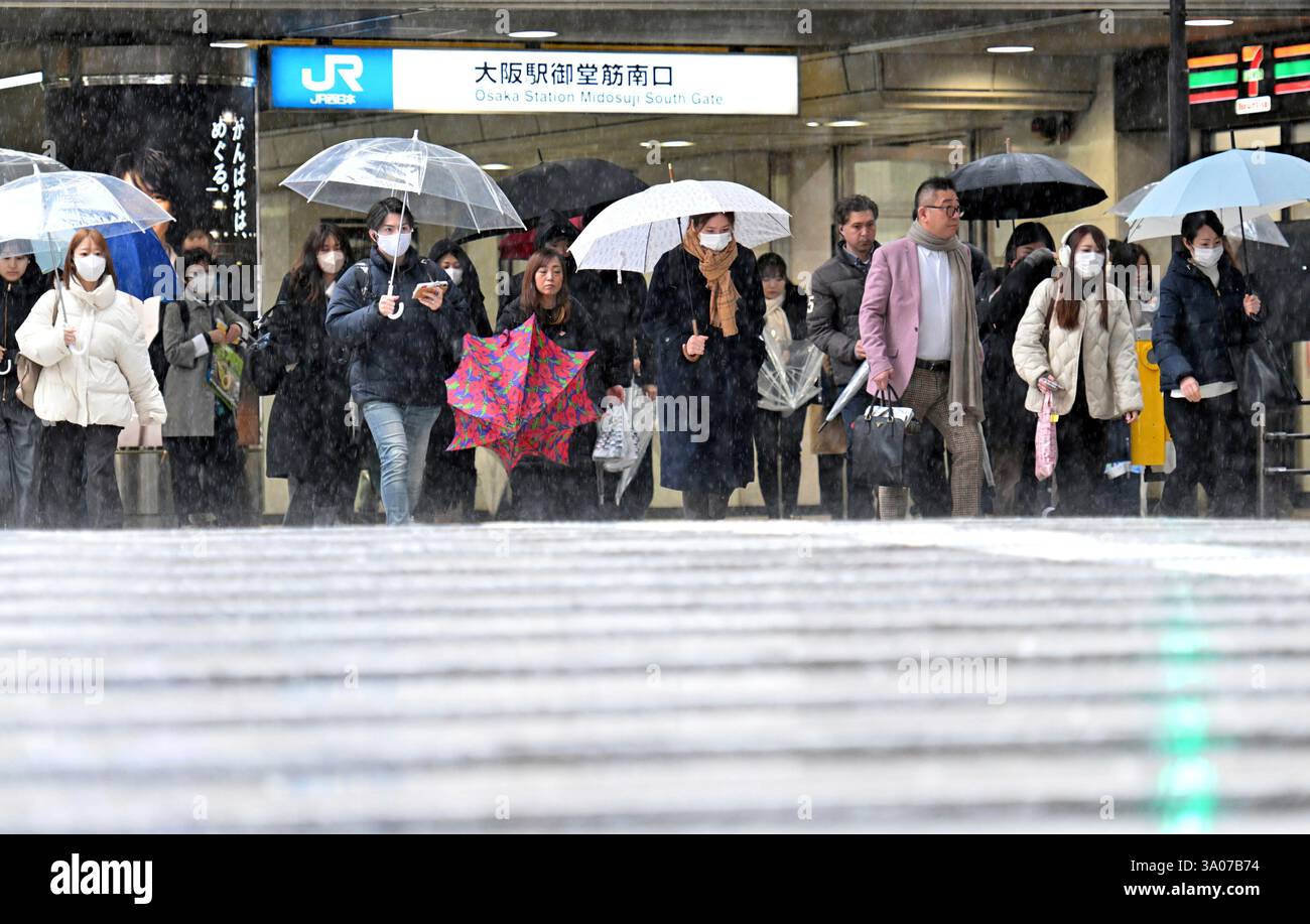 Commuters and others walk in the cold rain in near Osaka Station in ...