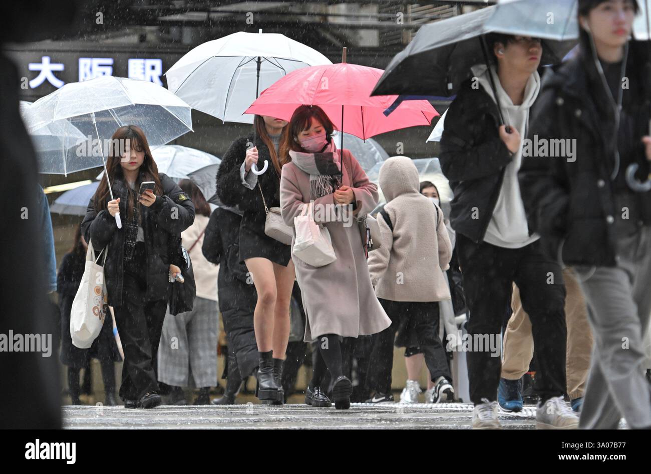 Commuters and others walk in the cold rain in near Osaka Station in ...