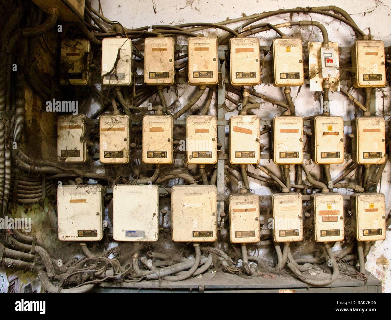 An old and tangled network of electricity meters and wiring inside a ...