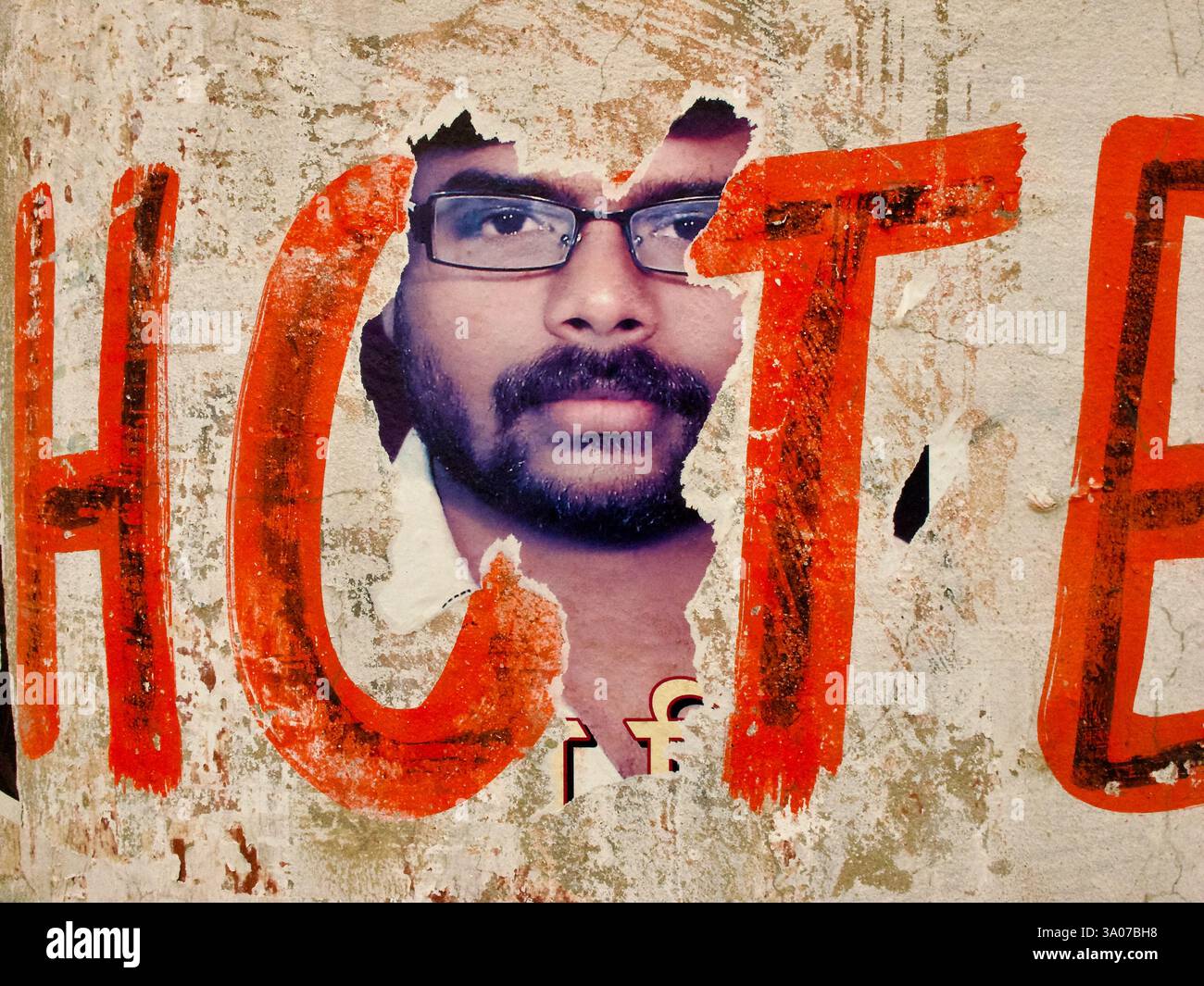 Layers of torn posters on a weathered wall in Varanasi reveal a ...