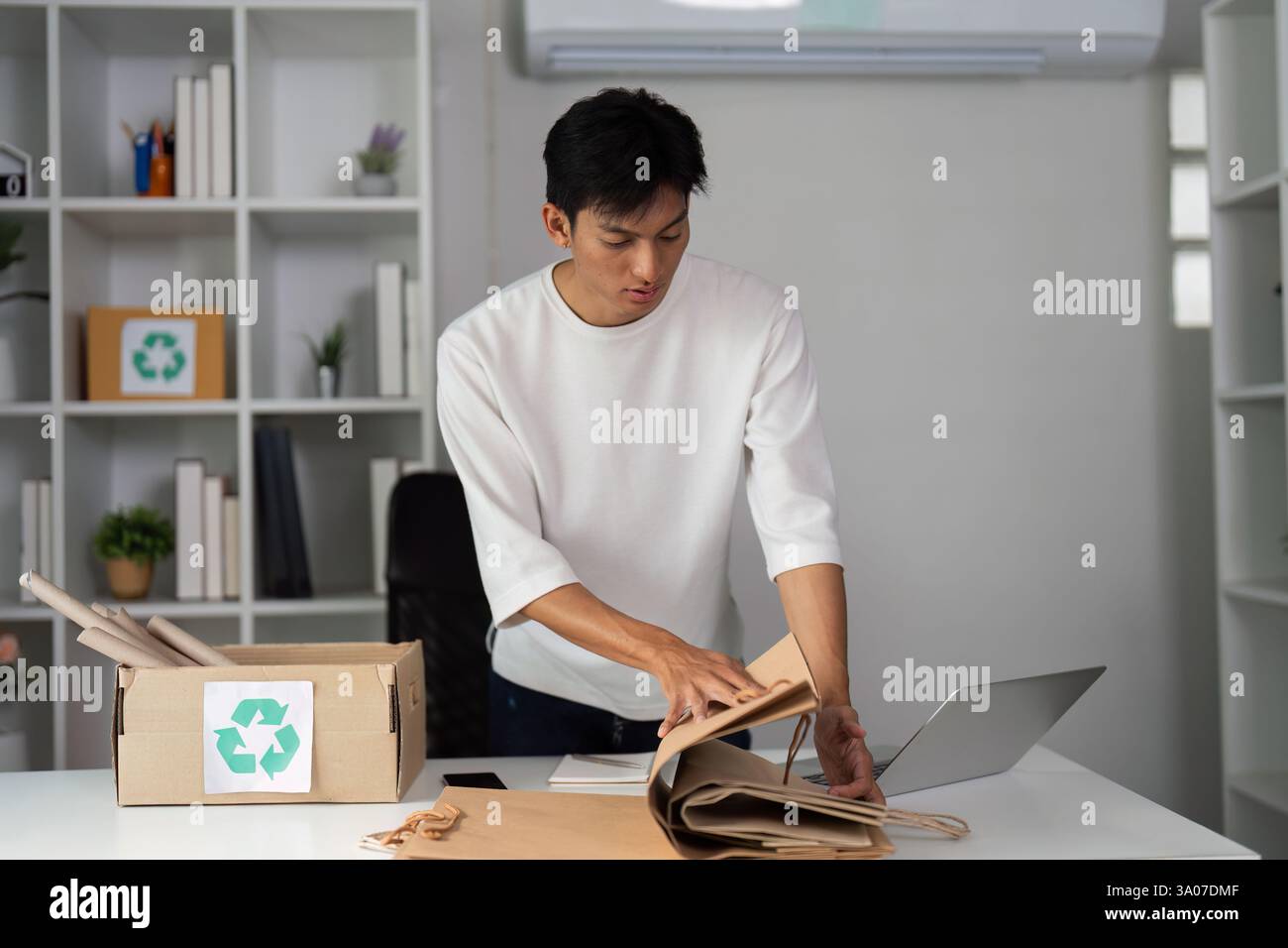 Young man organizing recyclable paper materials for eco-friendly ...