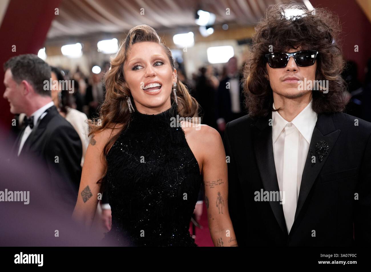 Miley Cyrus, left, and Maxx Morando arrive at the Oscars on Sunday ...