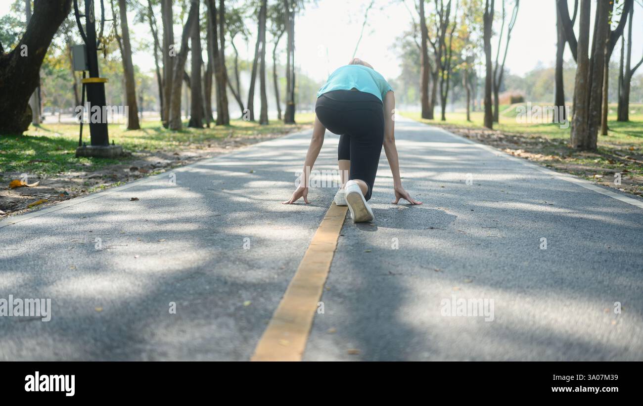 Sporty woman crouching down in starting position ready for sprint Stock ...