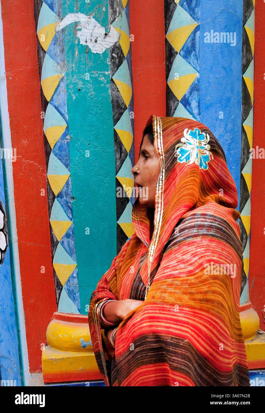 A woman standidng by the gate of Shri Bade Hanuman Ji temple in Ayodhya ...