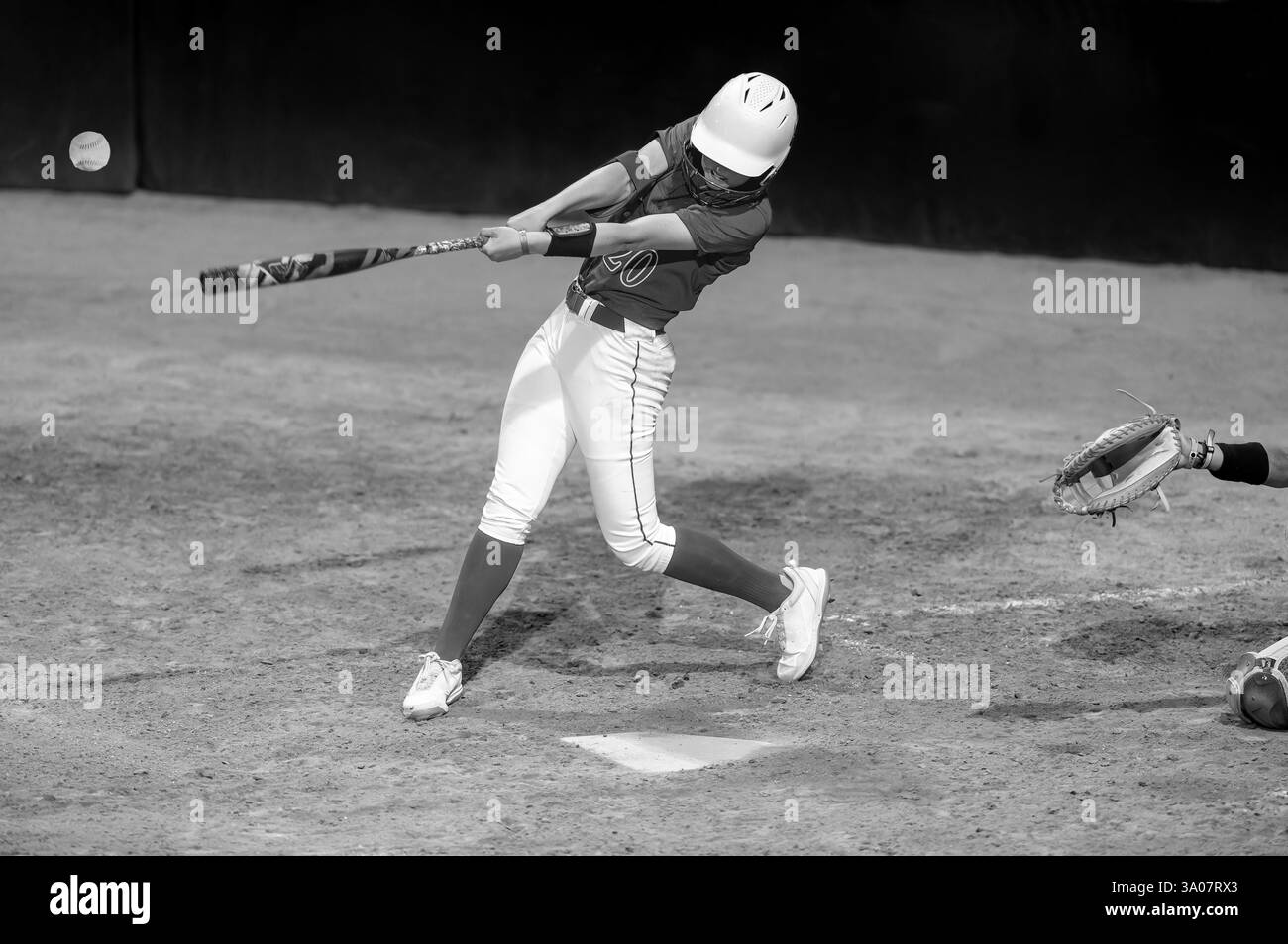 A Softball Player Is Swinging The Bat To Make Contact With The Baseball Black and White Stock ...