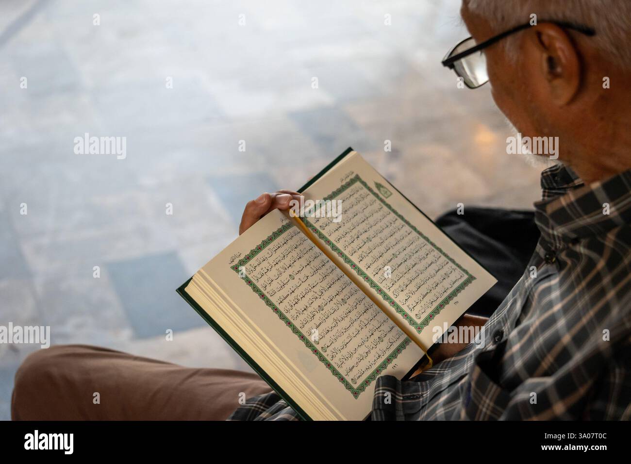 A close-up of a man reading the Quran at the mosque of the Foundation ...