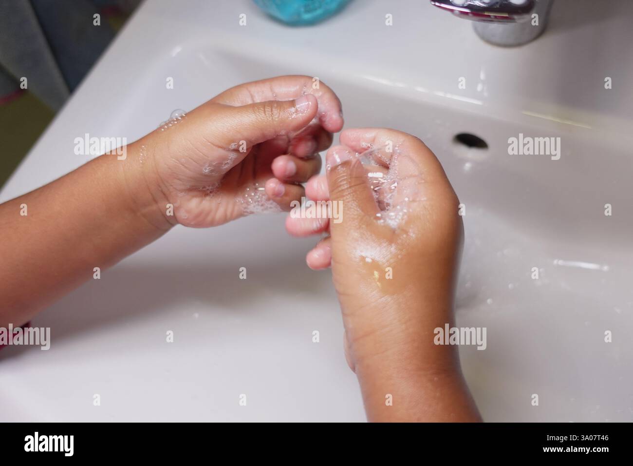Children washing hands at a sink to promote hygiene practices Stock ...