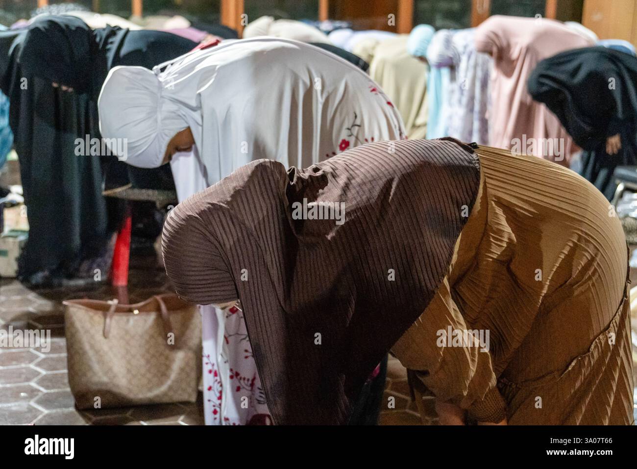 A close-up of Muslim women bowing down to the ground on the first day ...