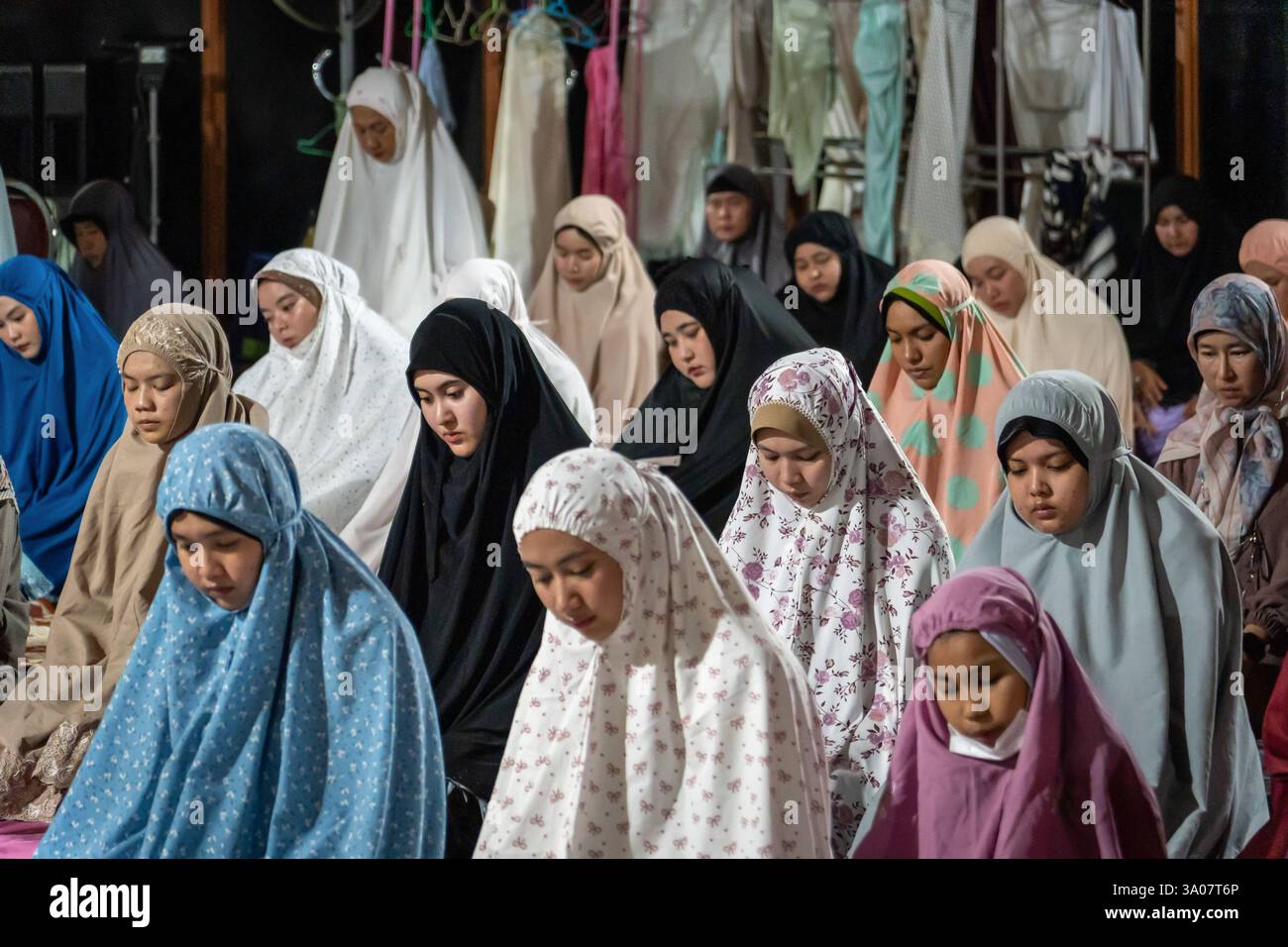A close-up of several female Muslim prayers on the first day of Ramadan ...