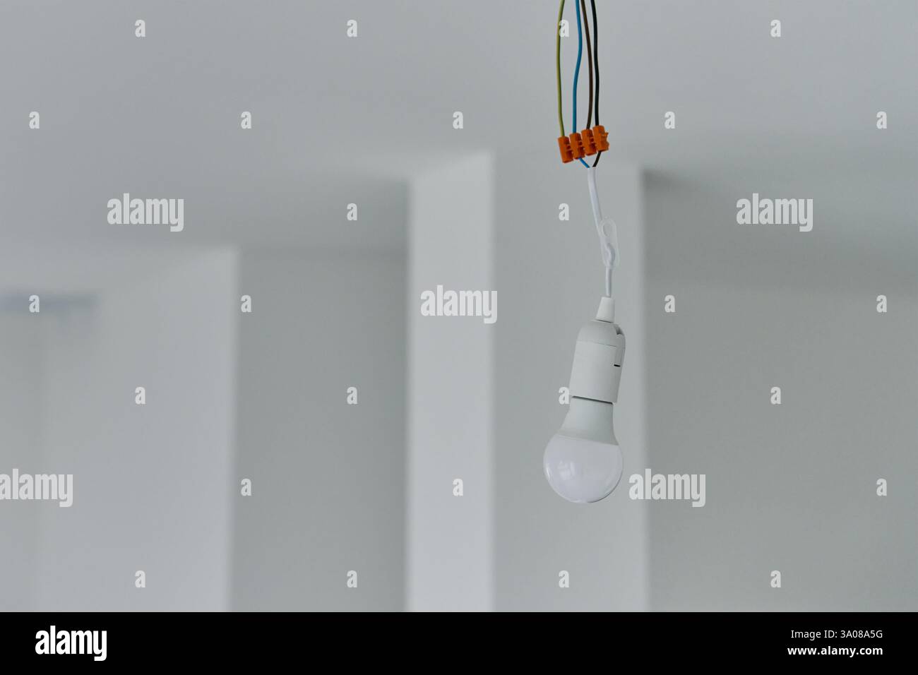 Single light bulb hanging from exposed electrical wires in unfinished ...