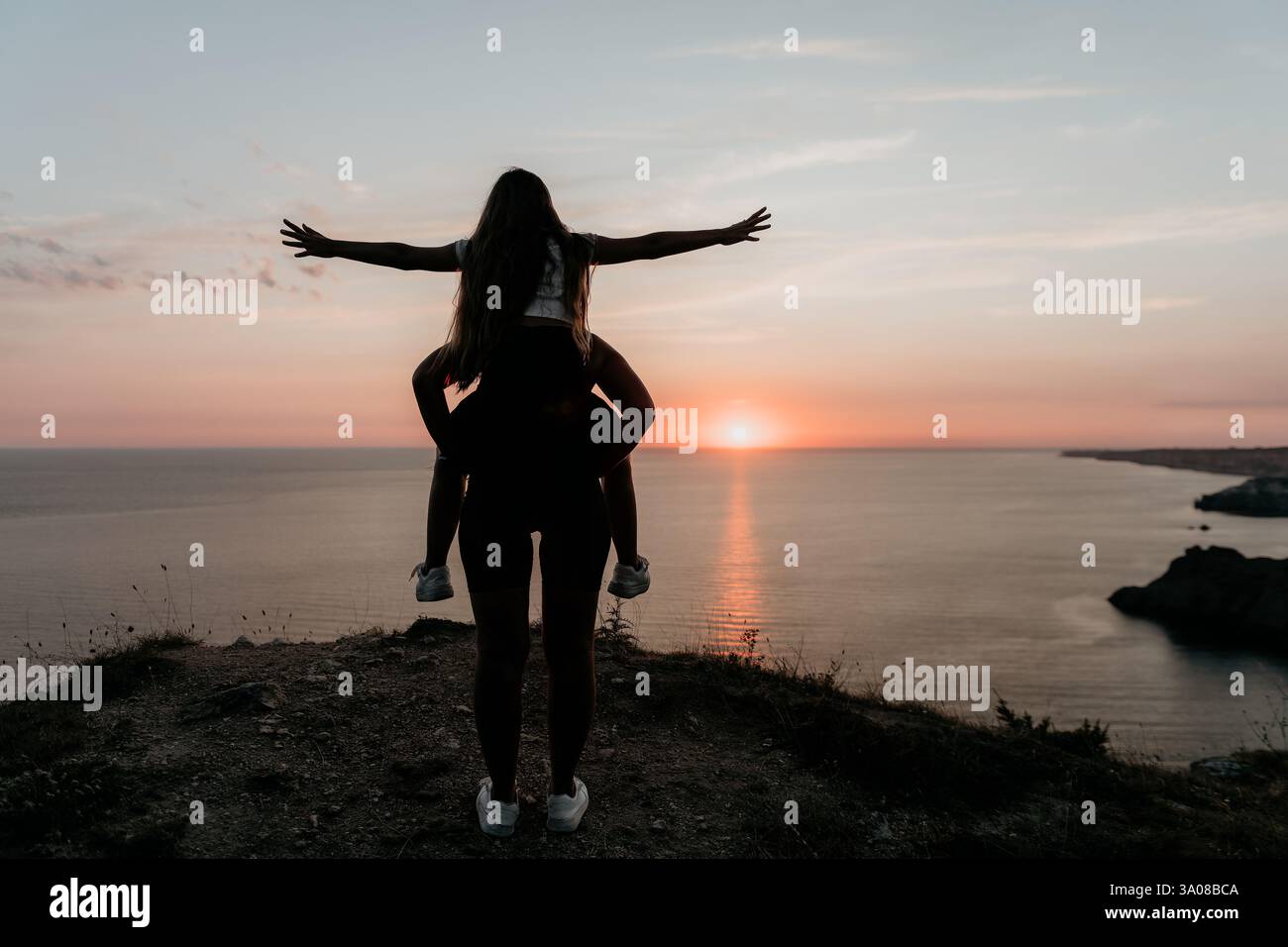 Mother and Daughter Silhouetted Against Sunset Stock Photo - Alamy