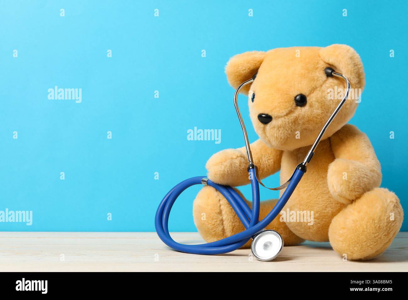 Pediatrics concept. Teddy bear with stethoscope on wooden table against ...
