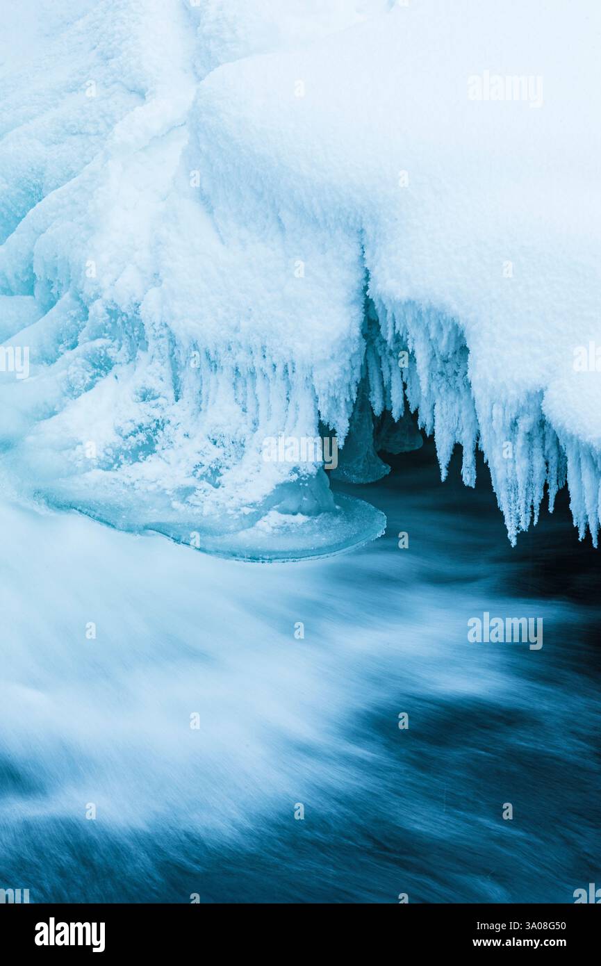 A serene winter creek in Sweden showcases stunning ice formations along ...