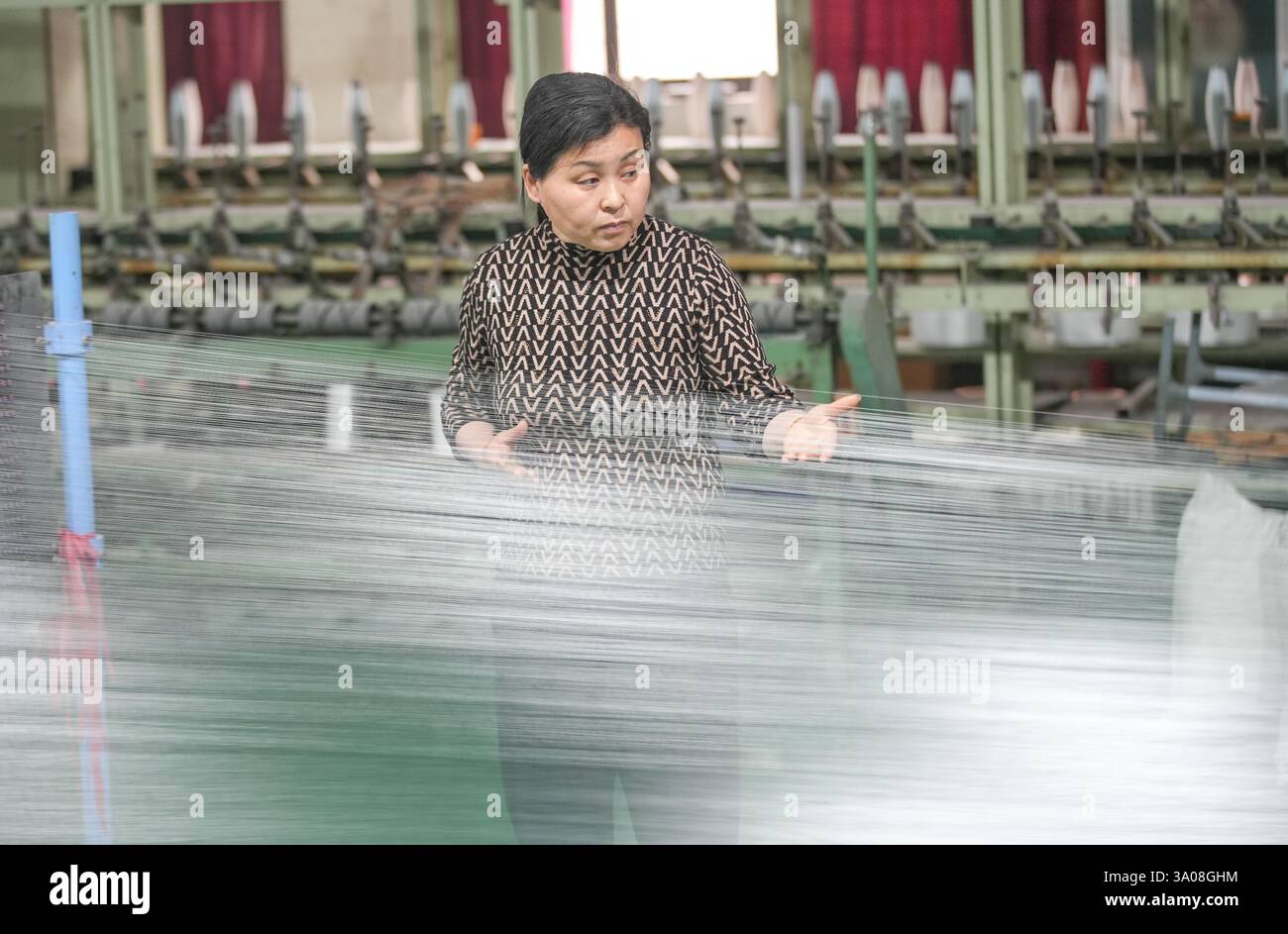 Huzhou, China. 03rd Mar, 2025. HUZHOU, CHINA - MARCH 3, 2025 - A worker produces textile ...
