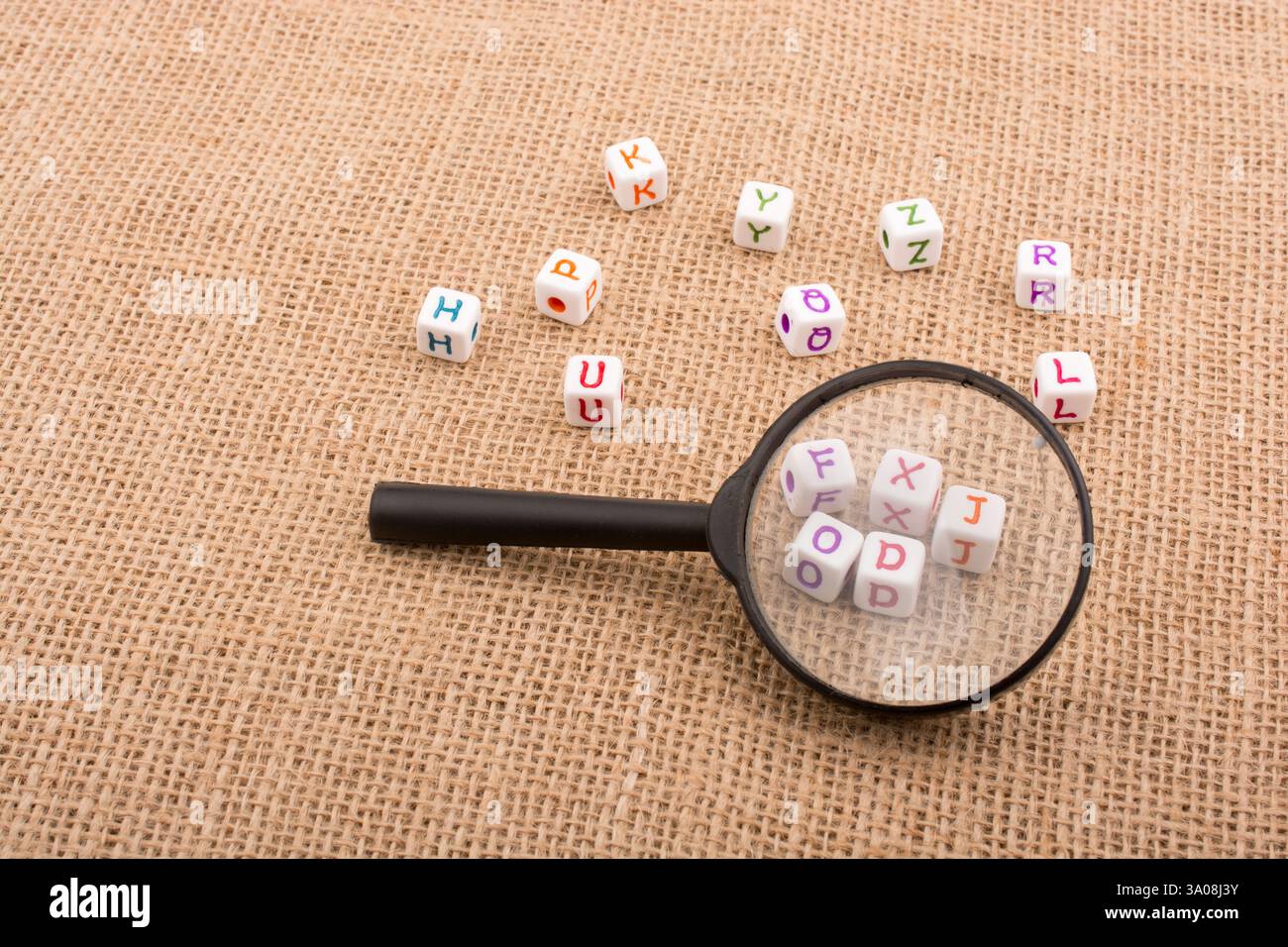 Colorful alphabet letter cubes behind a magnifying glass Stock Photo ...