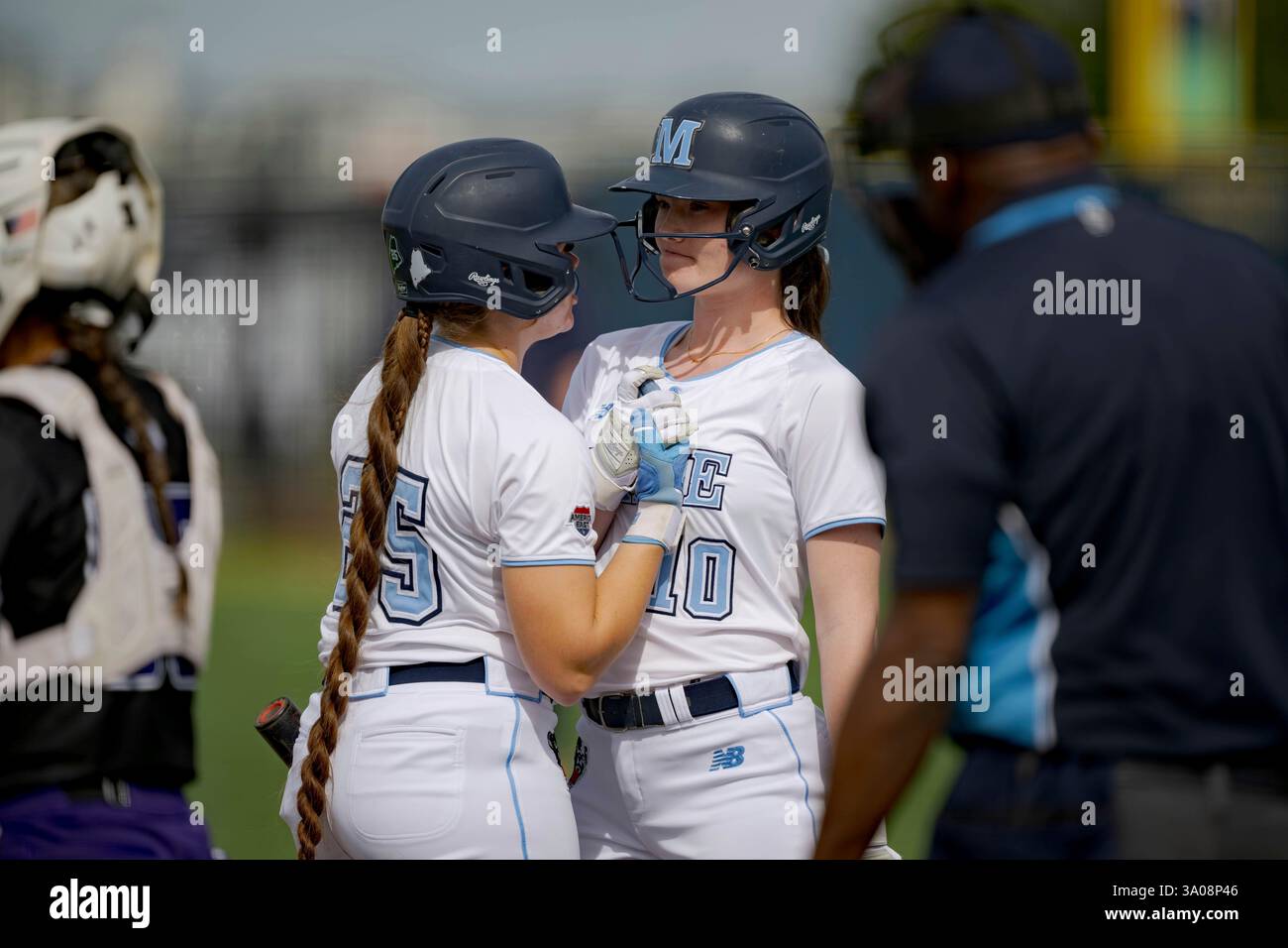 After scoring a run, Maine catcher Immy Gie (25) talks to on-deck ...