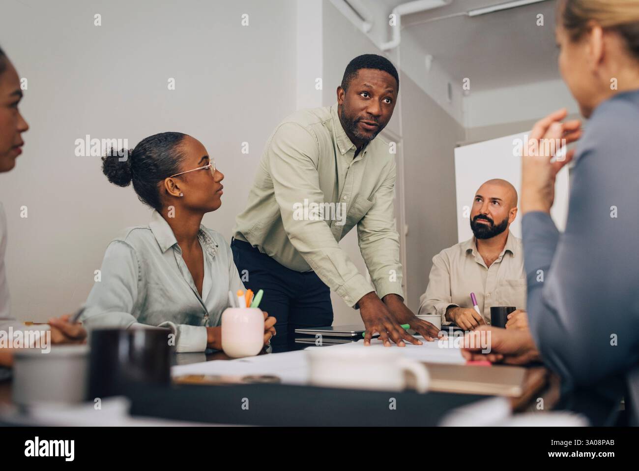 Male business professional explaining strategy to coworkers during ...