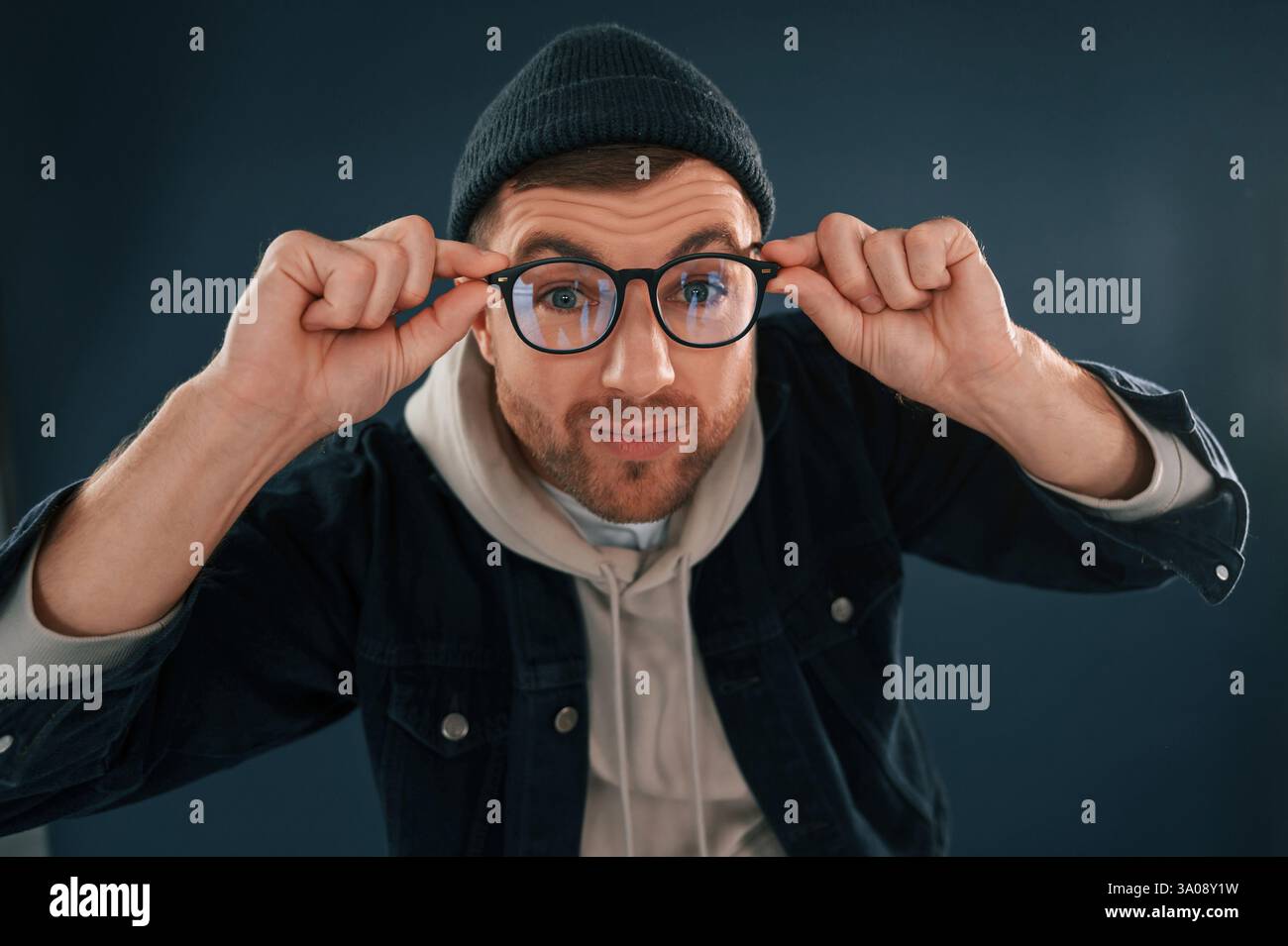 Funny guy playing with glasses. Handsome man is in the studio against ...