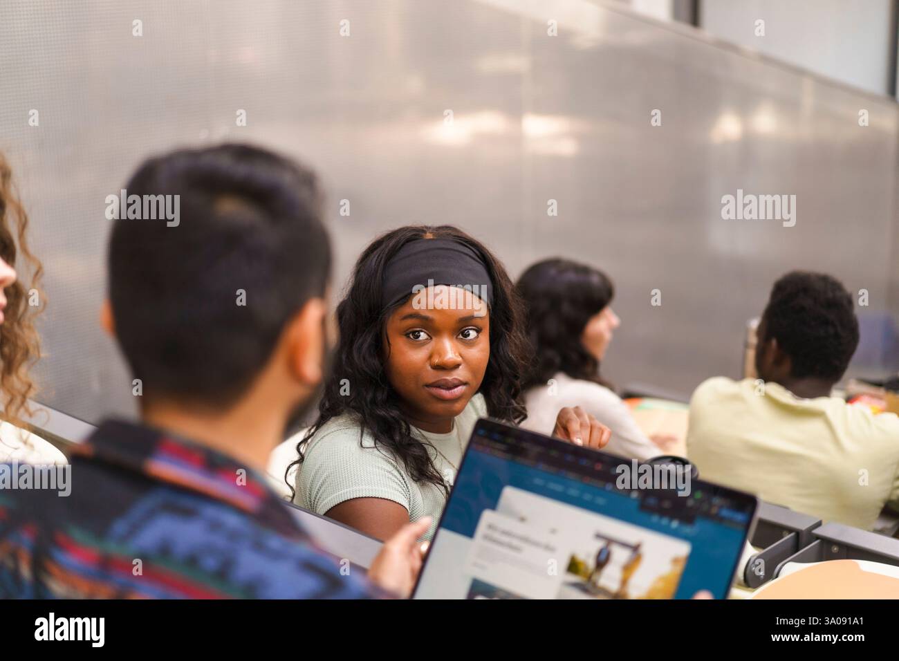 High angle view of young female student looking back while discussing ...